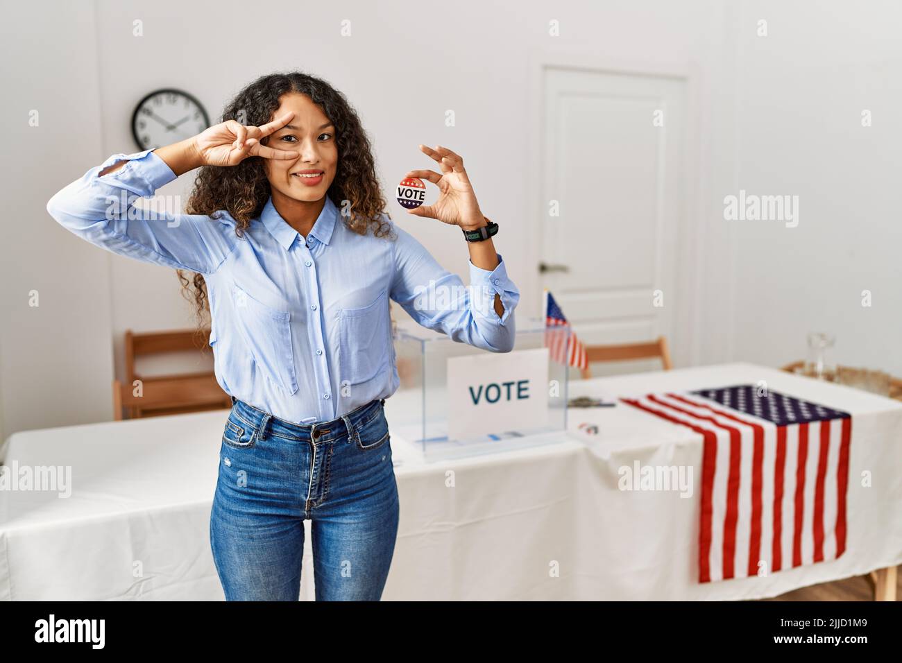 Beautiful hispanic woman standing by at political campaign by voting ...