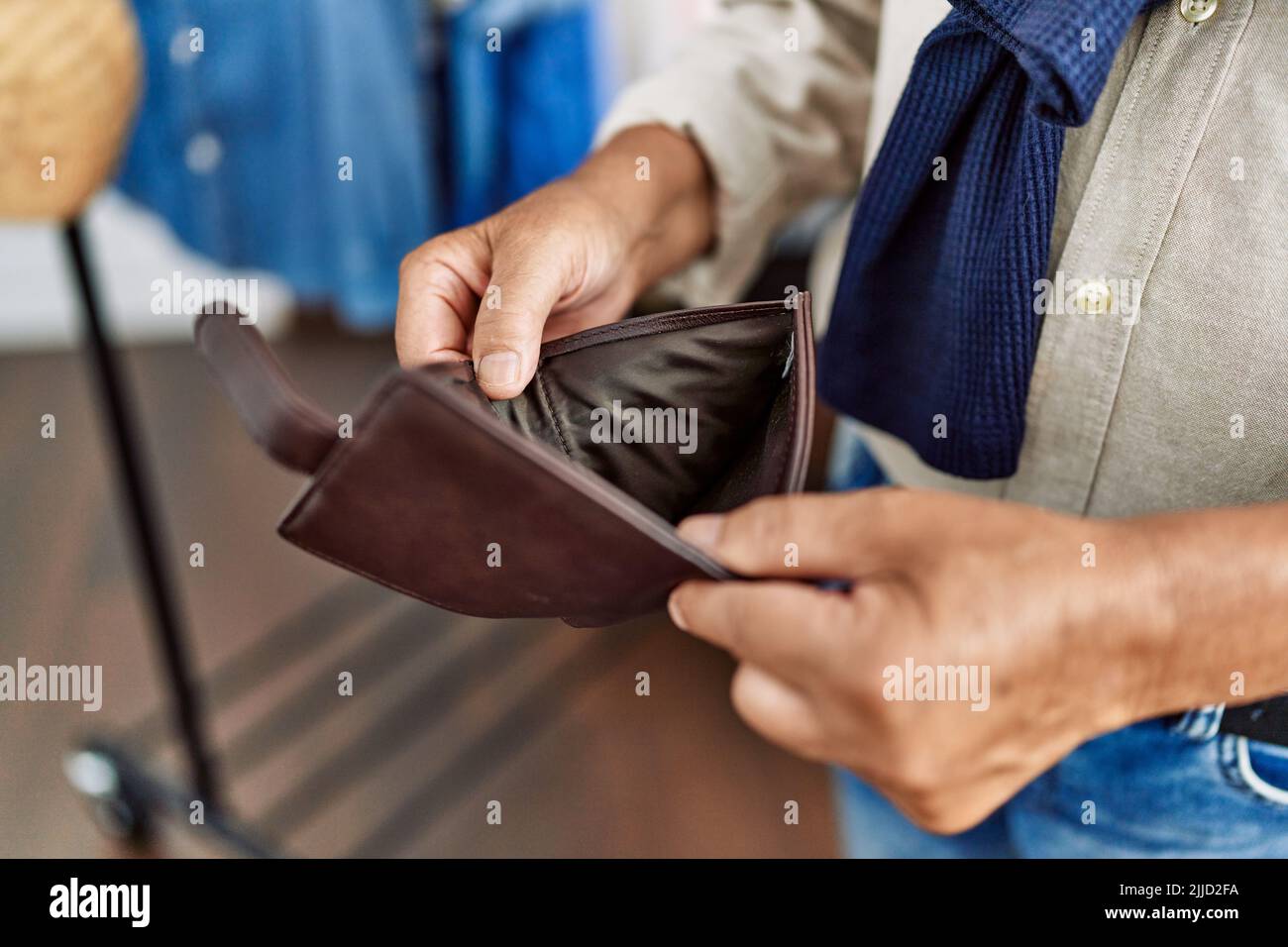 Senior grey-haired man showing empty wallet at clothing store Stock ...