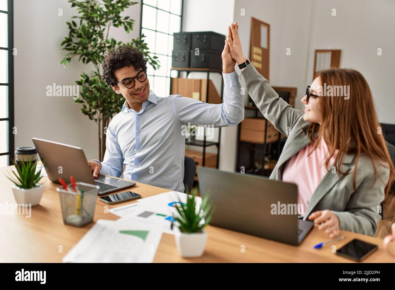 Two business workers smiling happy high five at the office Stock Photo ...