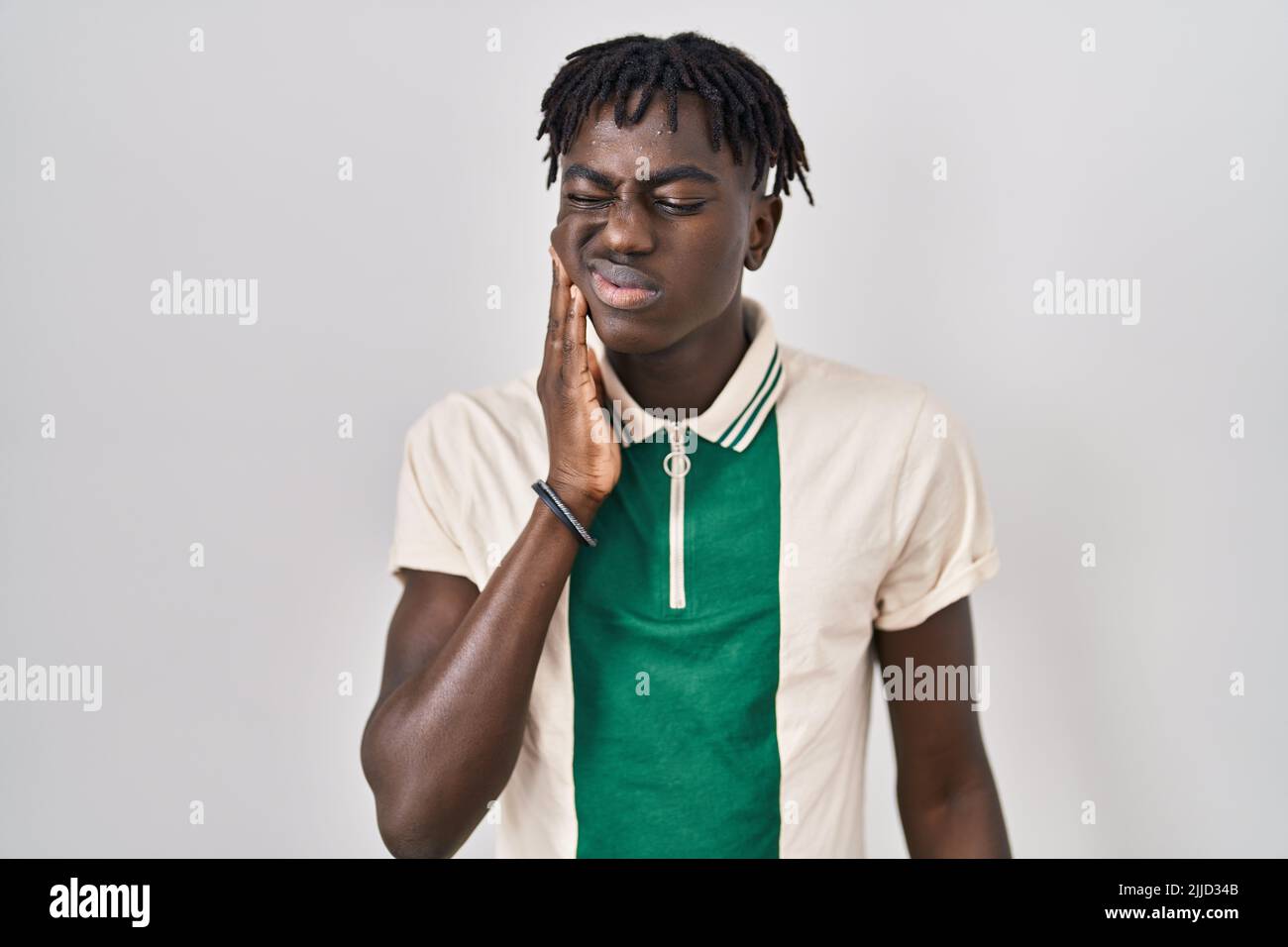 African man with dreadlocks standing over isolated background touching ...