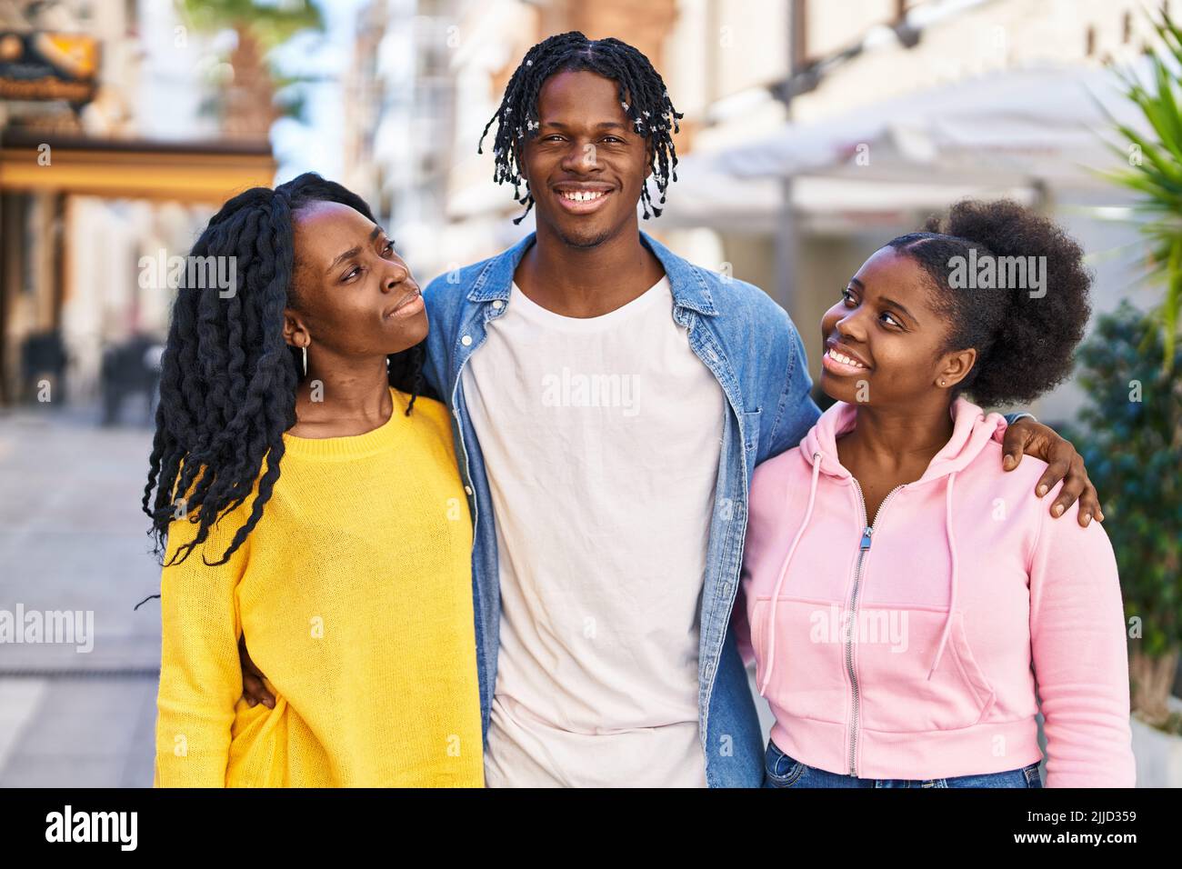 African american friends smiling confident hugging each other at street ...