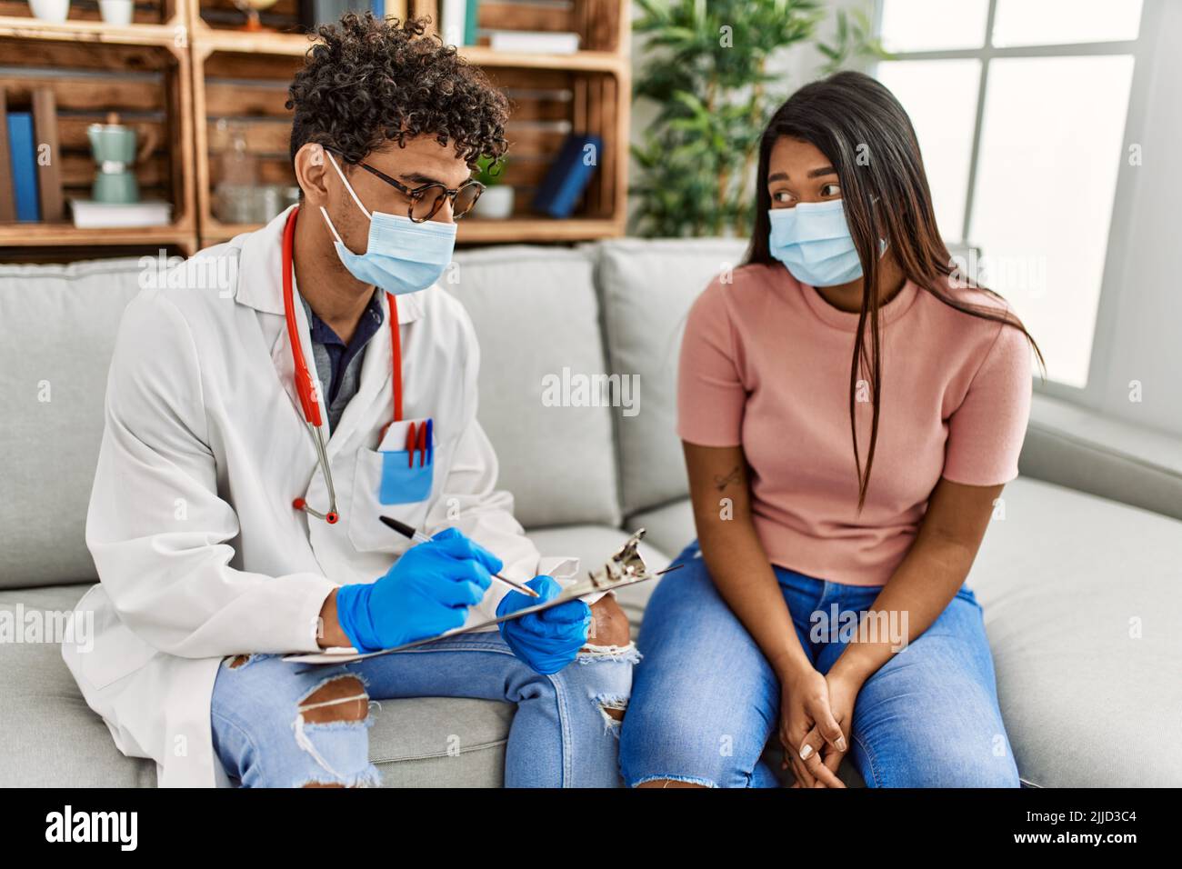 Young doctor man reading patient checklist report sitting on the sofa ...