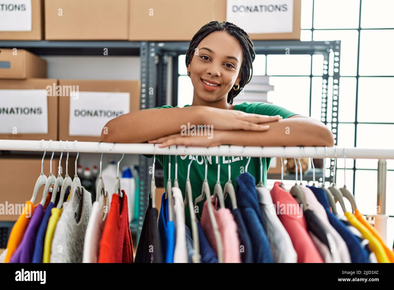 Young african american woman wearing volunteer uniform leaning on ...