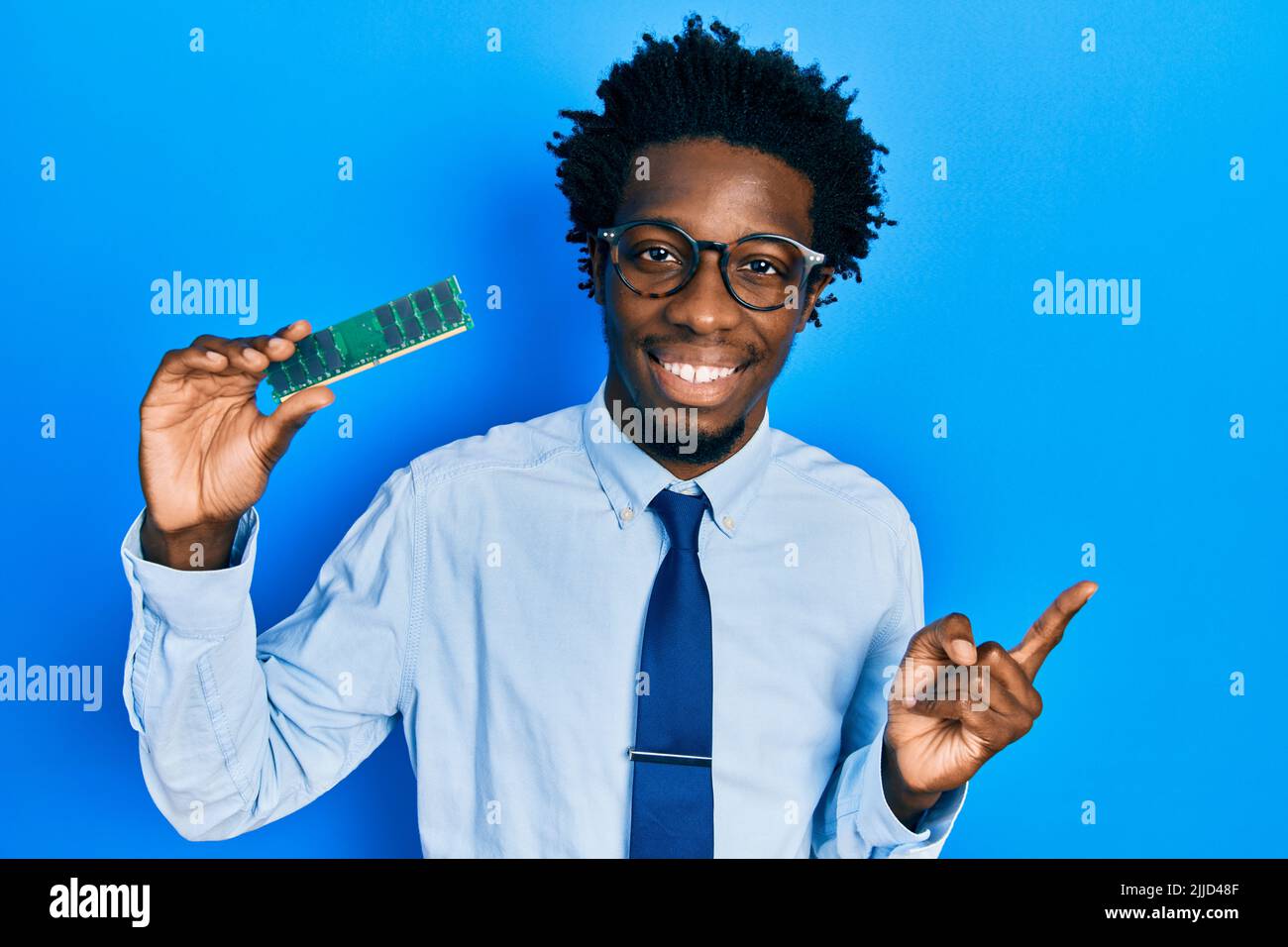 Young african american man holding computer ram smiling happy pointing ...
