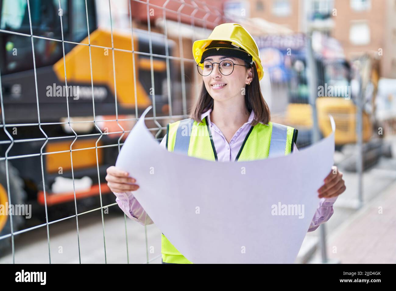 Young hispanic woman architect reading plans at street Stock Photo - Alamy