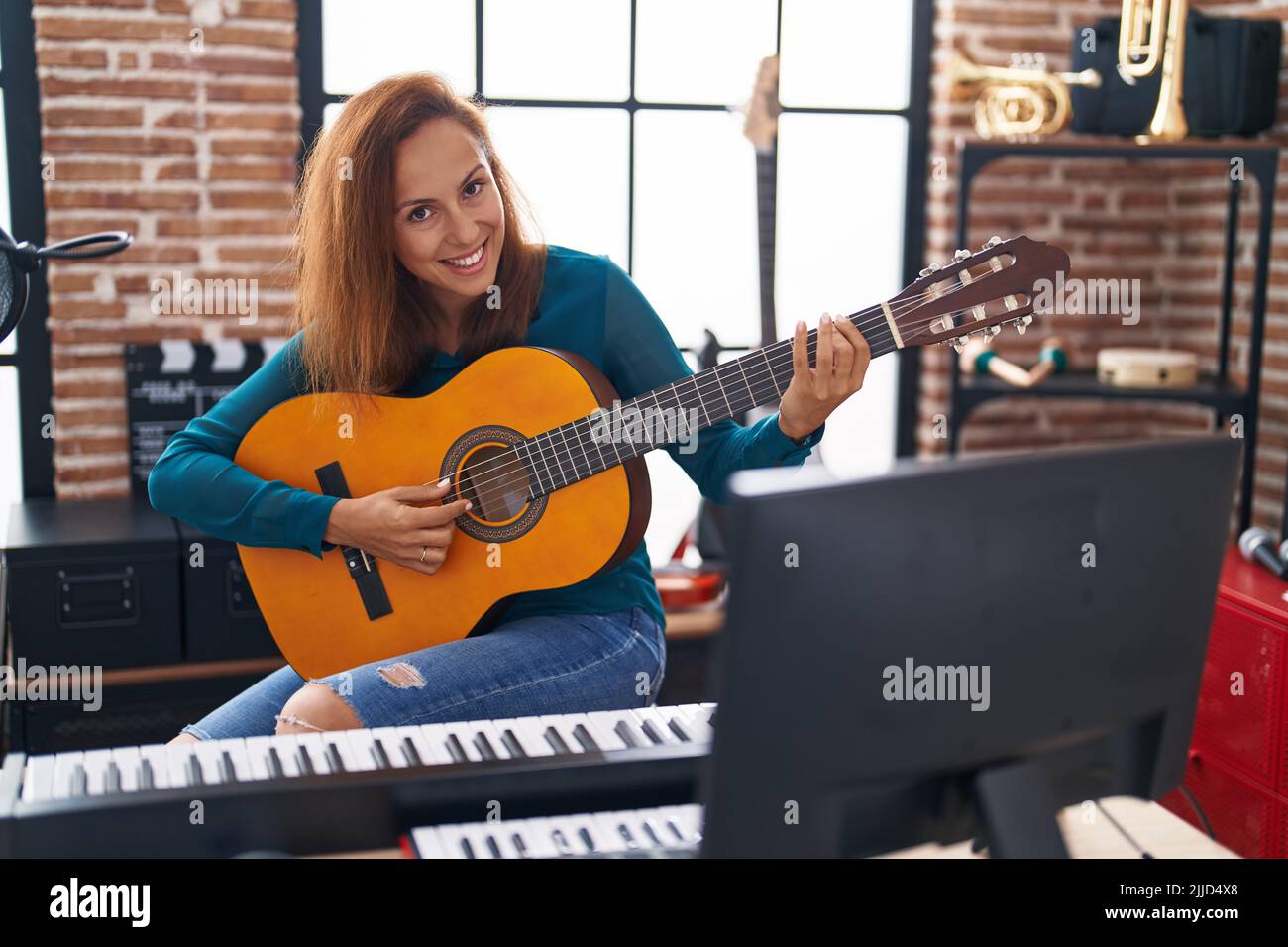 Young woman musician playing classical guitar at music studio Stock ...