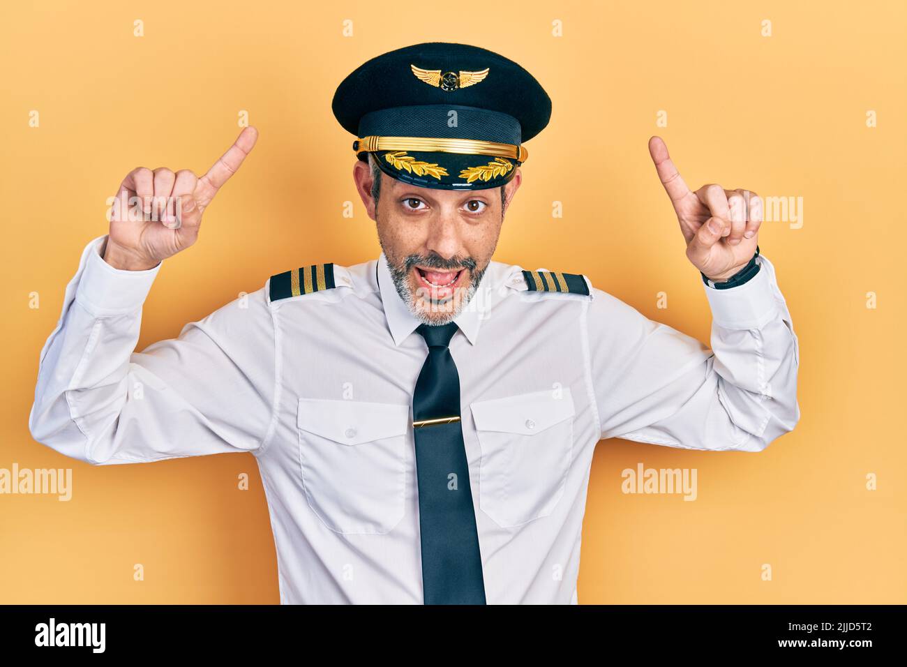 Handsome middle age man with grey hair wearing airplane pilot uniform ...