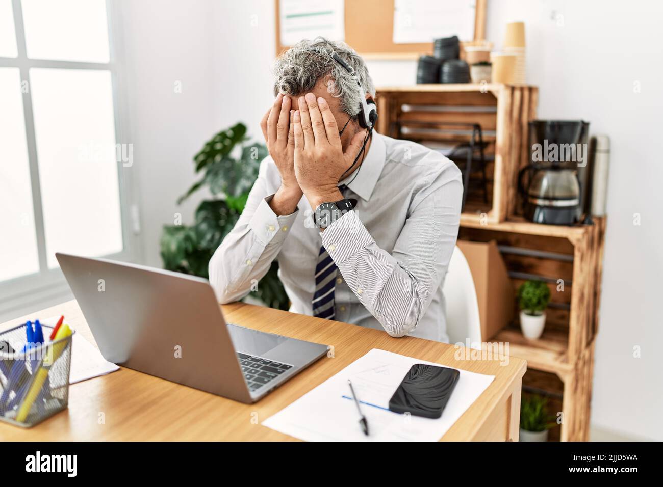 Middle age hispanic business man working at the office wearing operator ...