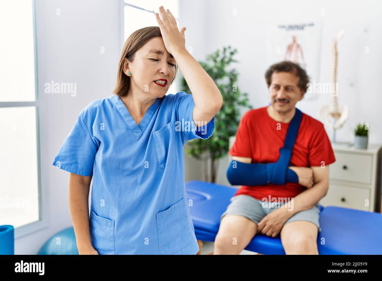 Middle age doctor woman with patient with arm injury at rehabilitation ...