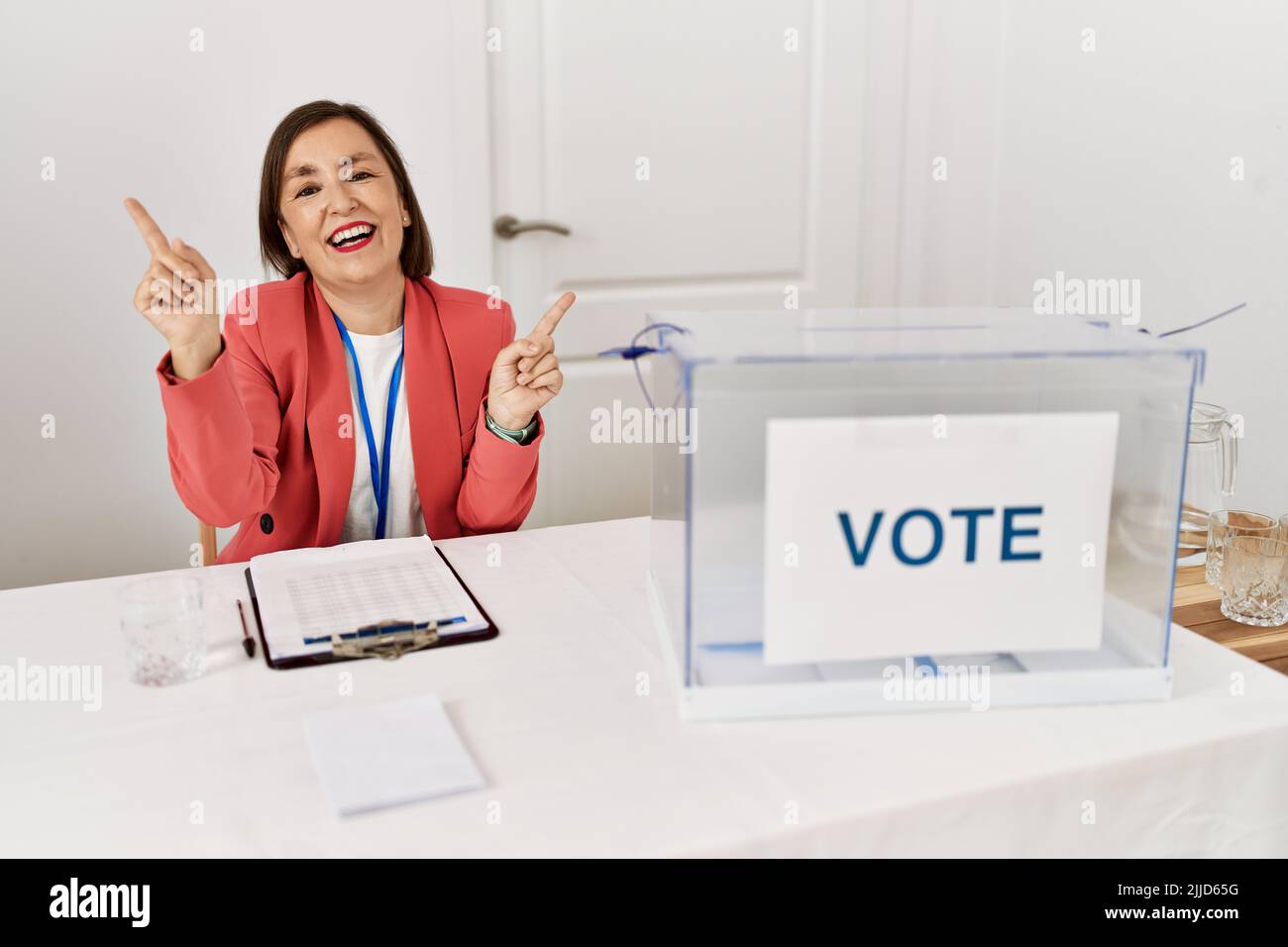 Beautiful middle age hispanic woman at political election sitting by ...