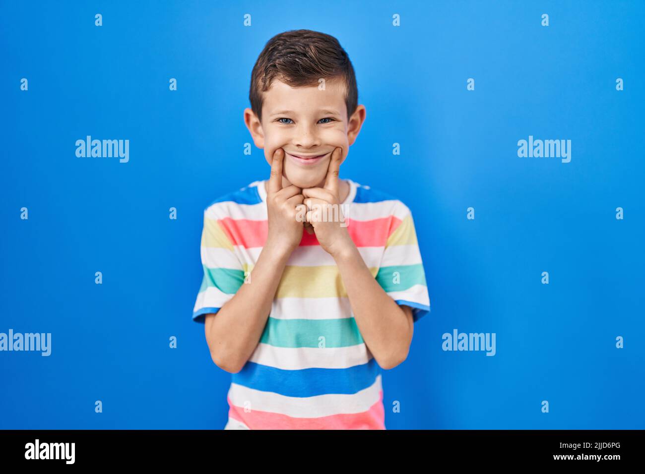 Young caucasian kid standing over blue background smiling with open ...