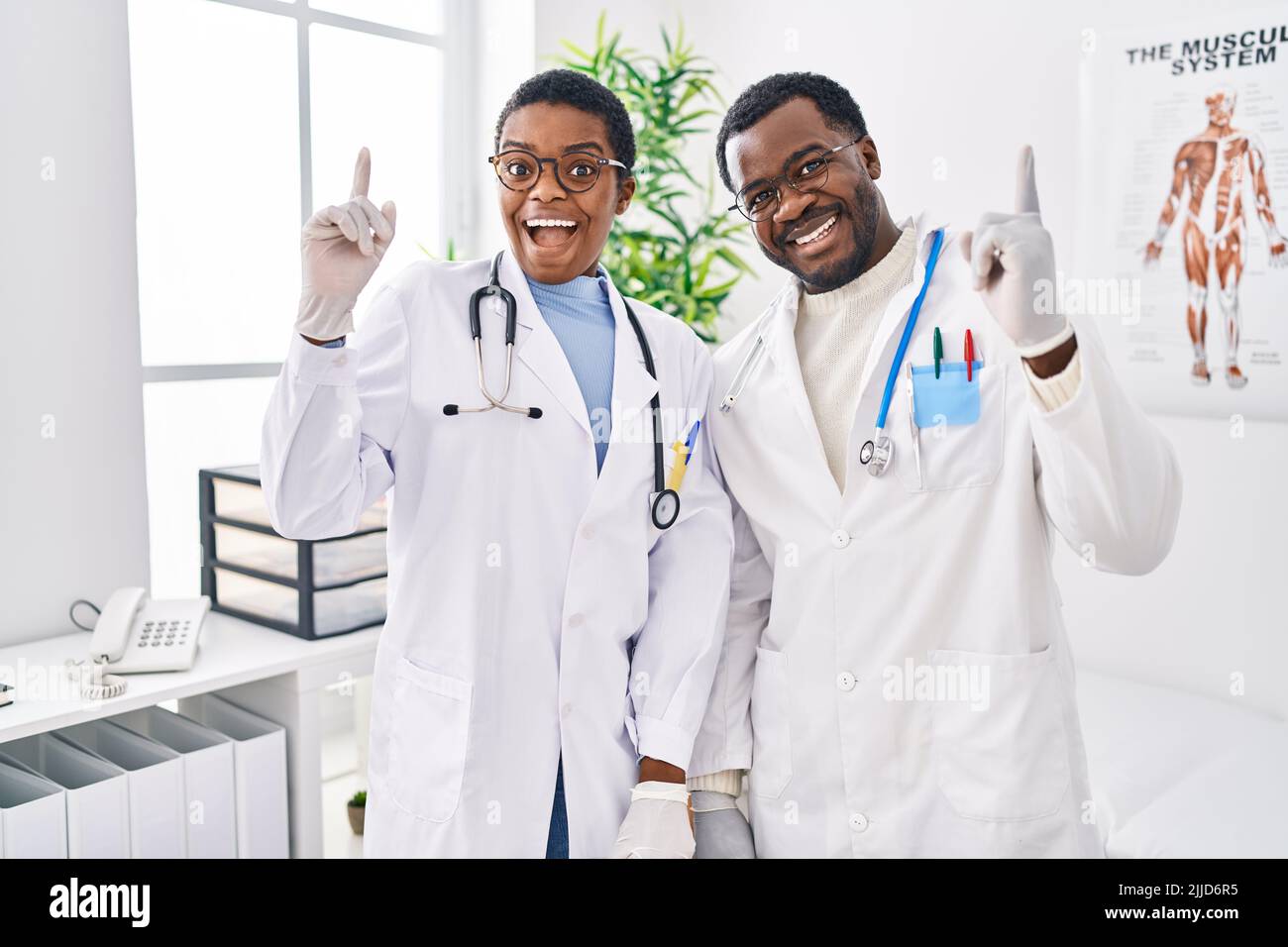 Young african american doctors working at medical clinic pointing ...