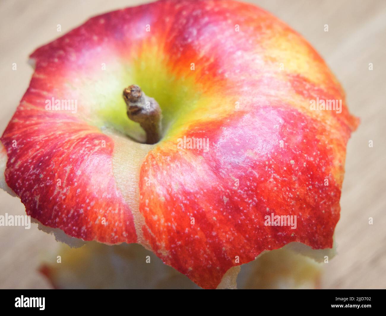 Red apple core on a wooden background. A bitten apple close-up Stock Photo - Alamy