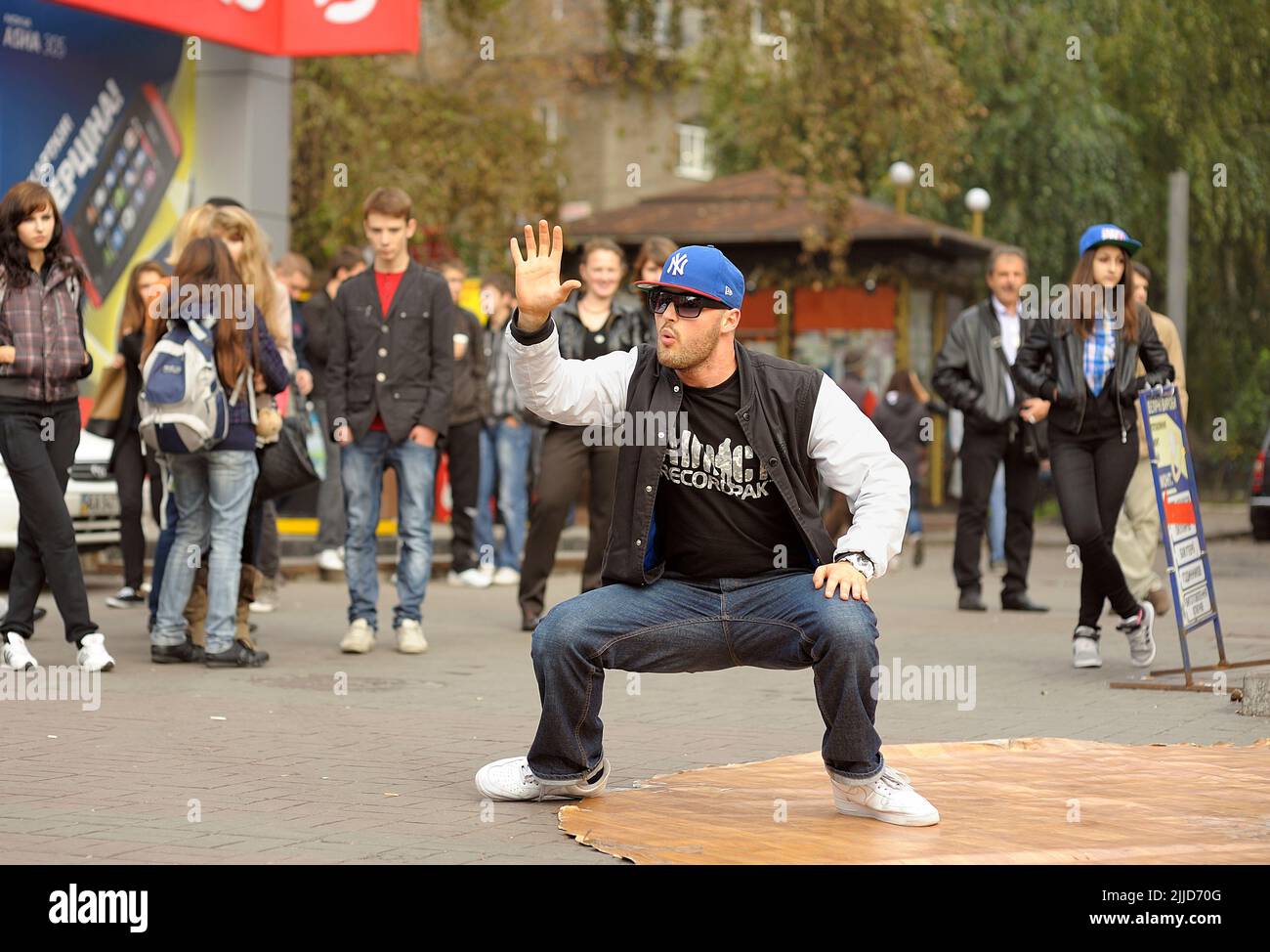 Young boy dancing break dance on the street, crowd of people watching ...