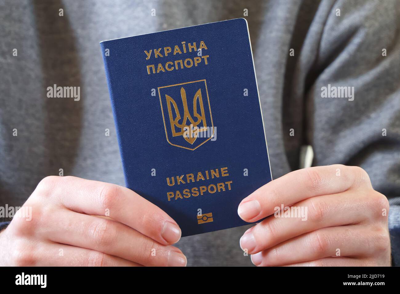 Ukrainian Biometric Passport In The Hand Of Its Owner In Close Up Stock