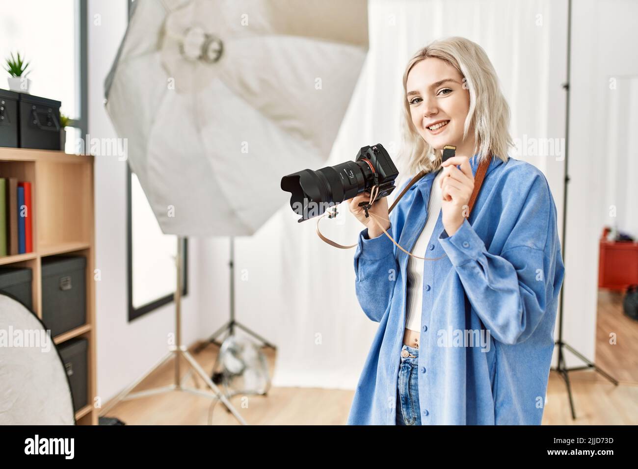 Beautiful blonde woman working as professional photographer at ...