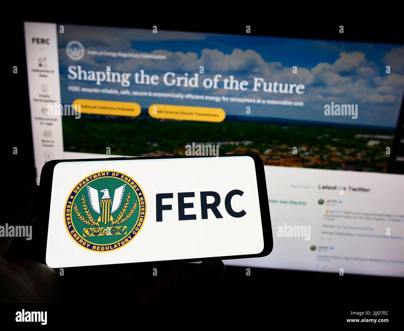 Person holding mobile phone with logo of US Federal Energy Regulatory Commission (FERC) on ...