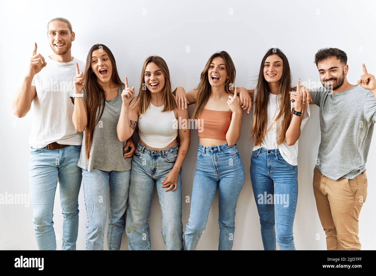 Group of young friends standing together over isolated background ...