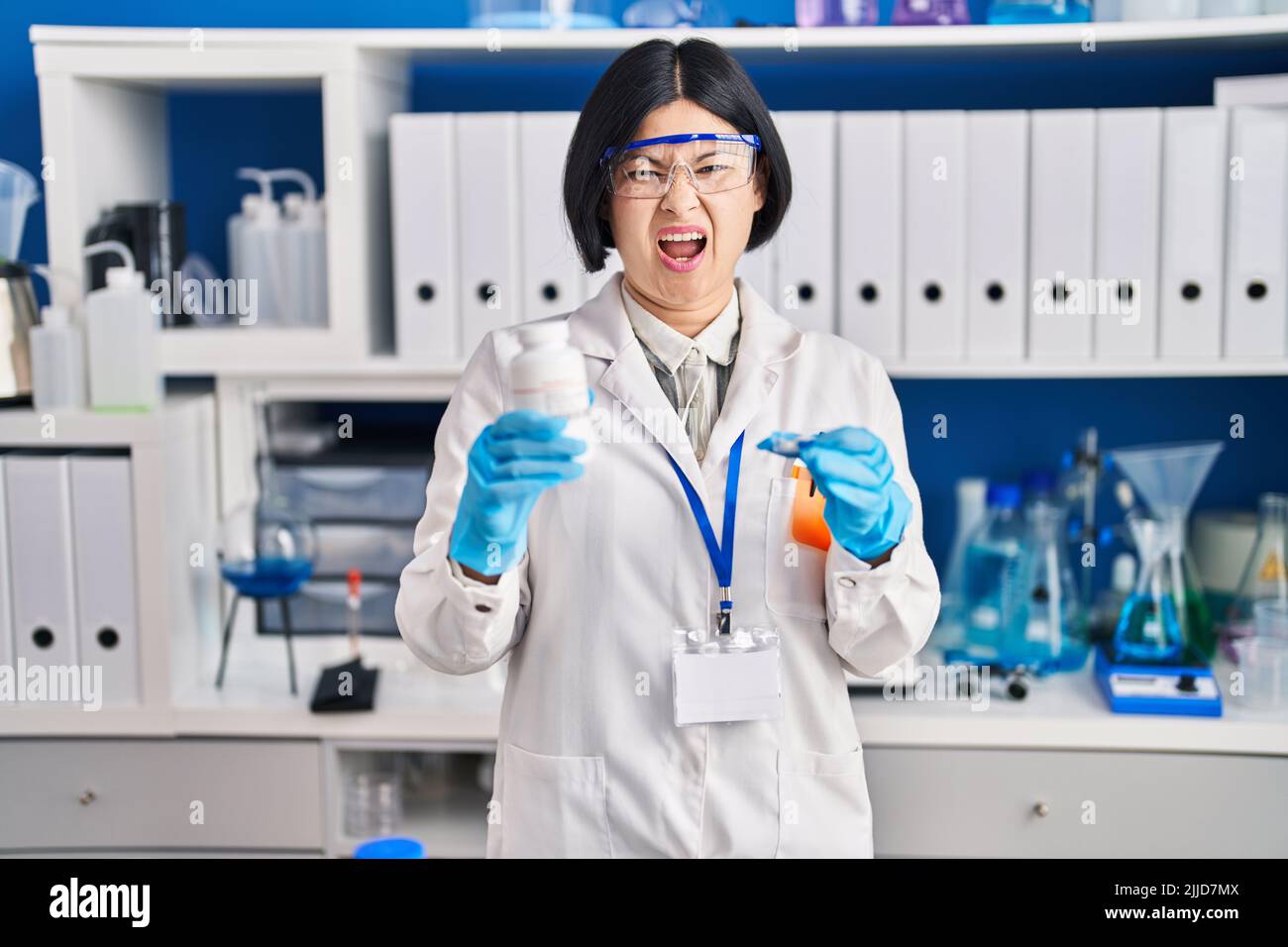 Young asian woman working at scientist laboratory angry and mad ...