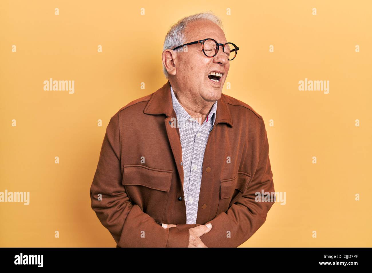 Senior man with grey hair wearing casual jacket and glasses with hand ...