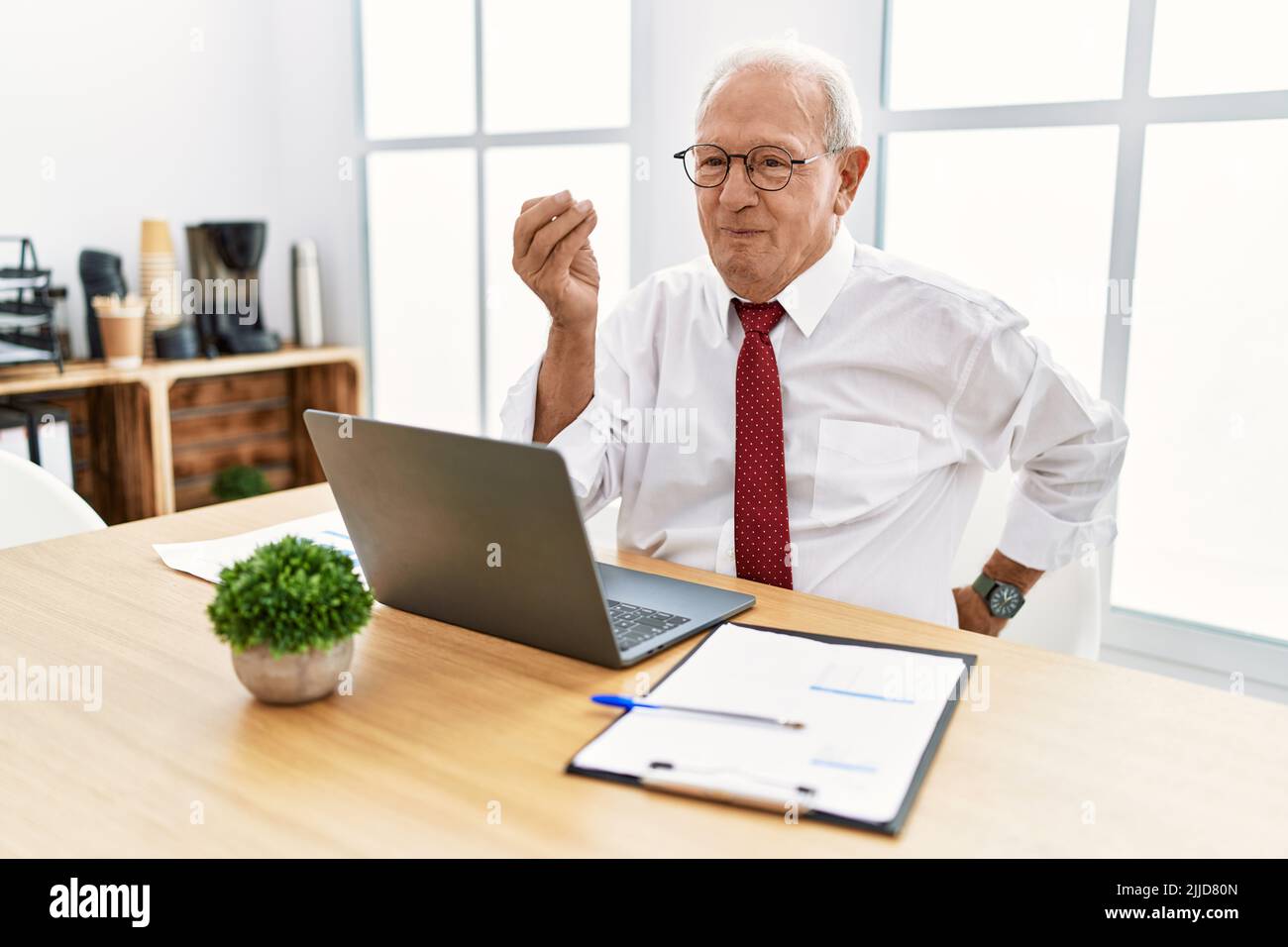 Senior man working at the office using computer laptop doing italian ...