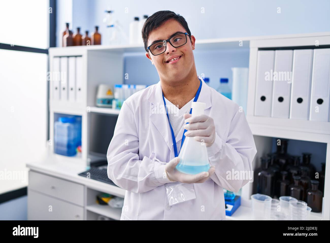Down syndrome man wearing scientist uniform holding test tube at ...