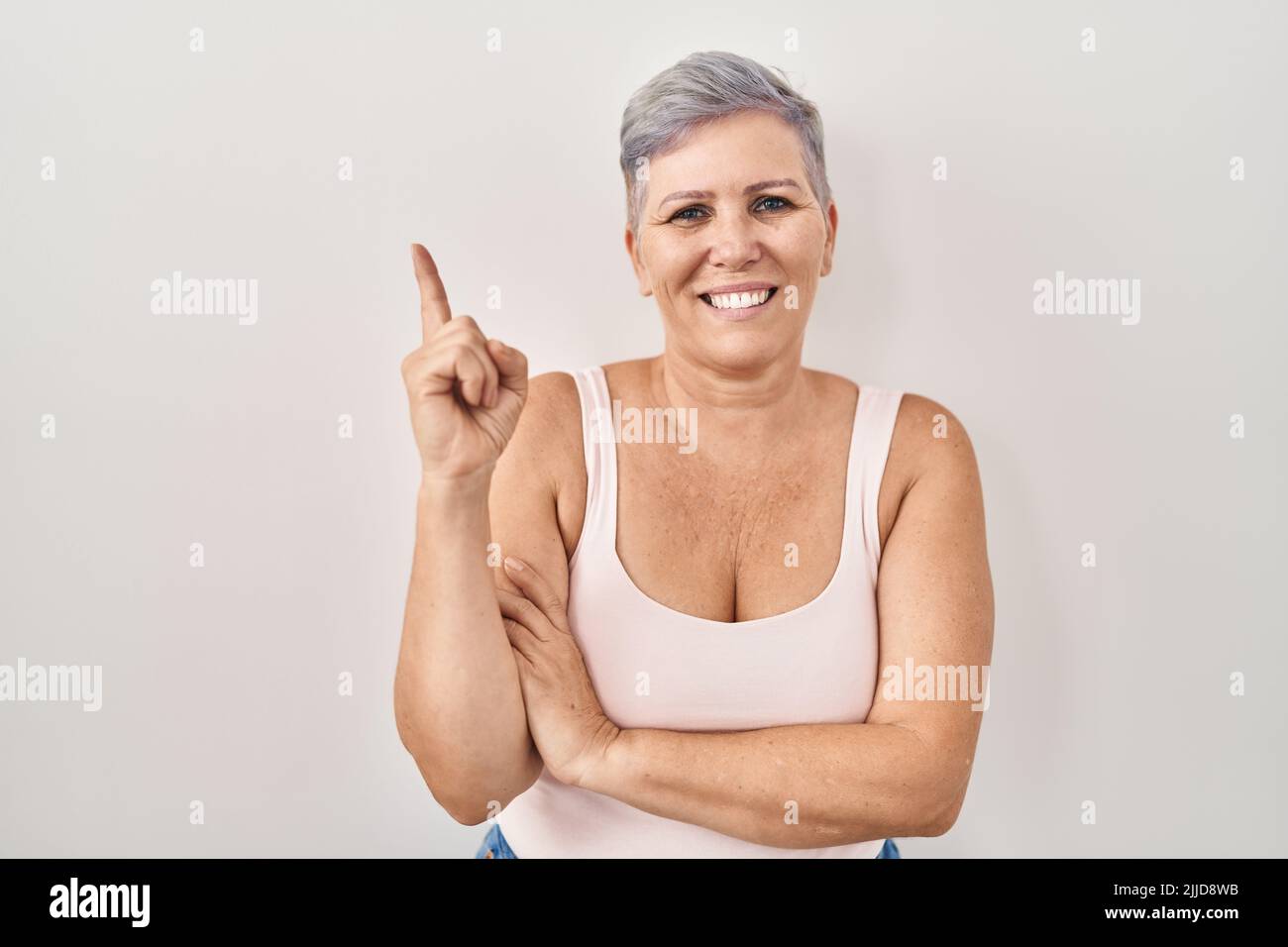Middle age caucasian woman standing over white background with a big ...