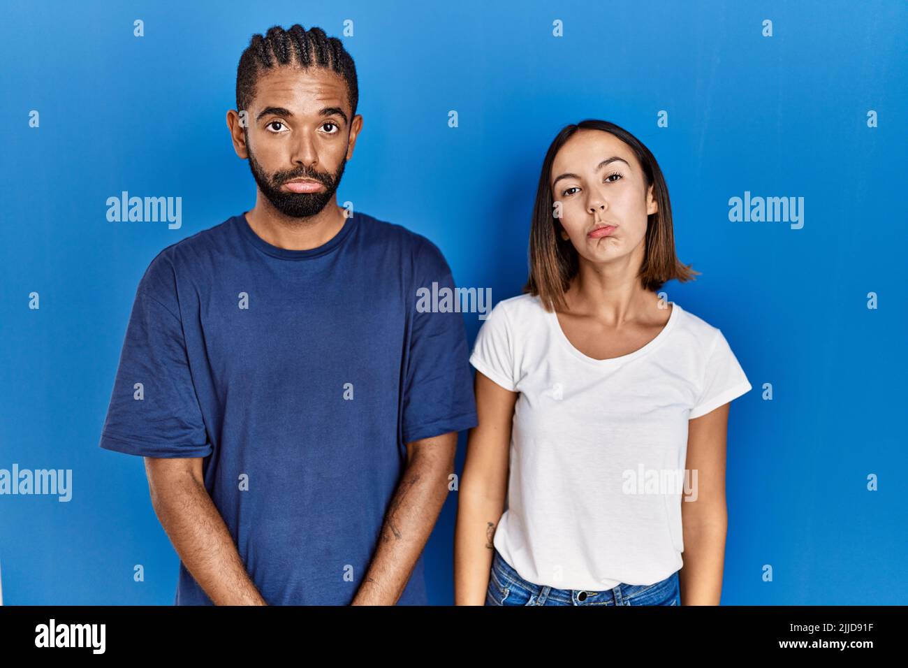 Young hispanic couple standing together depressed and worry for ...