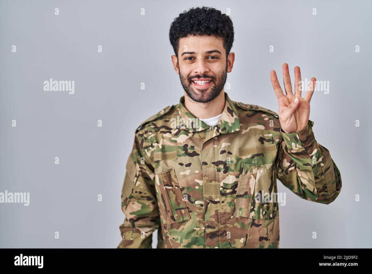 Arab man wearing camouflage army uniform showing and pointing up with ...