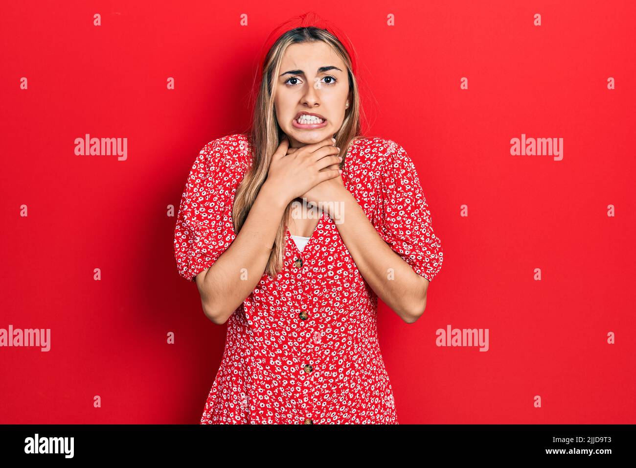Beautiful hispanic woman wearing summer dress shouting and suffocate ...