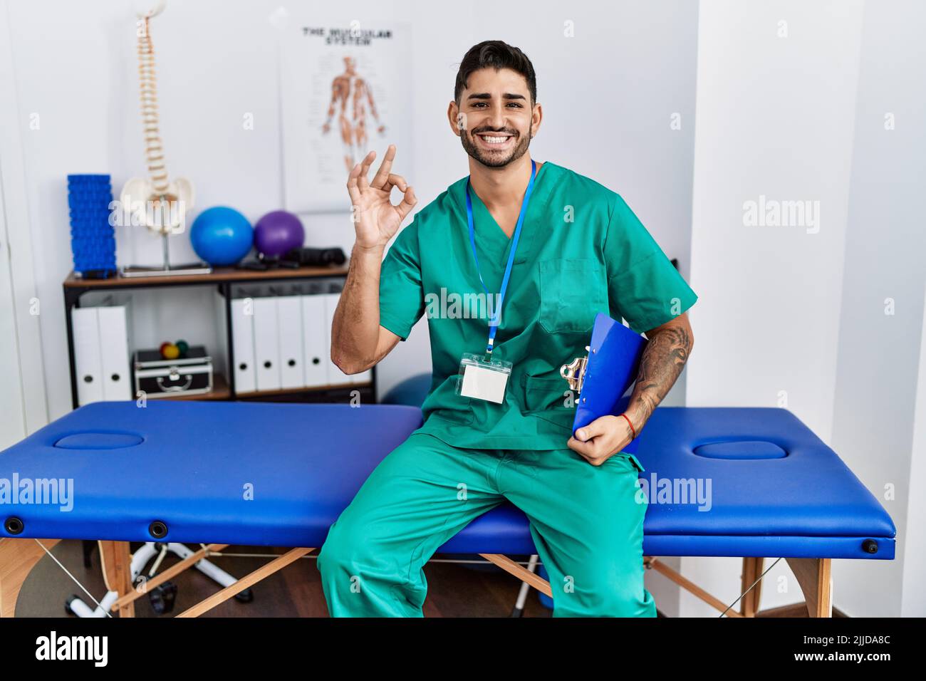 Young physiotherapist man working at pain recovery clinic smiling ...