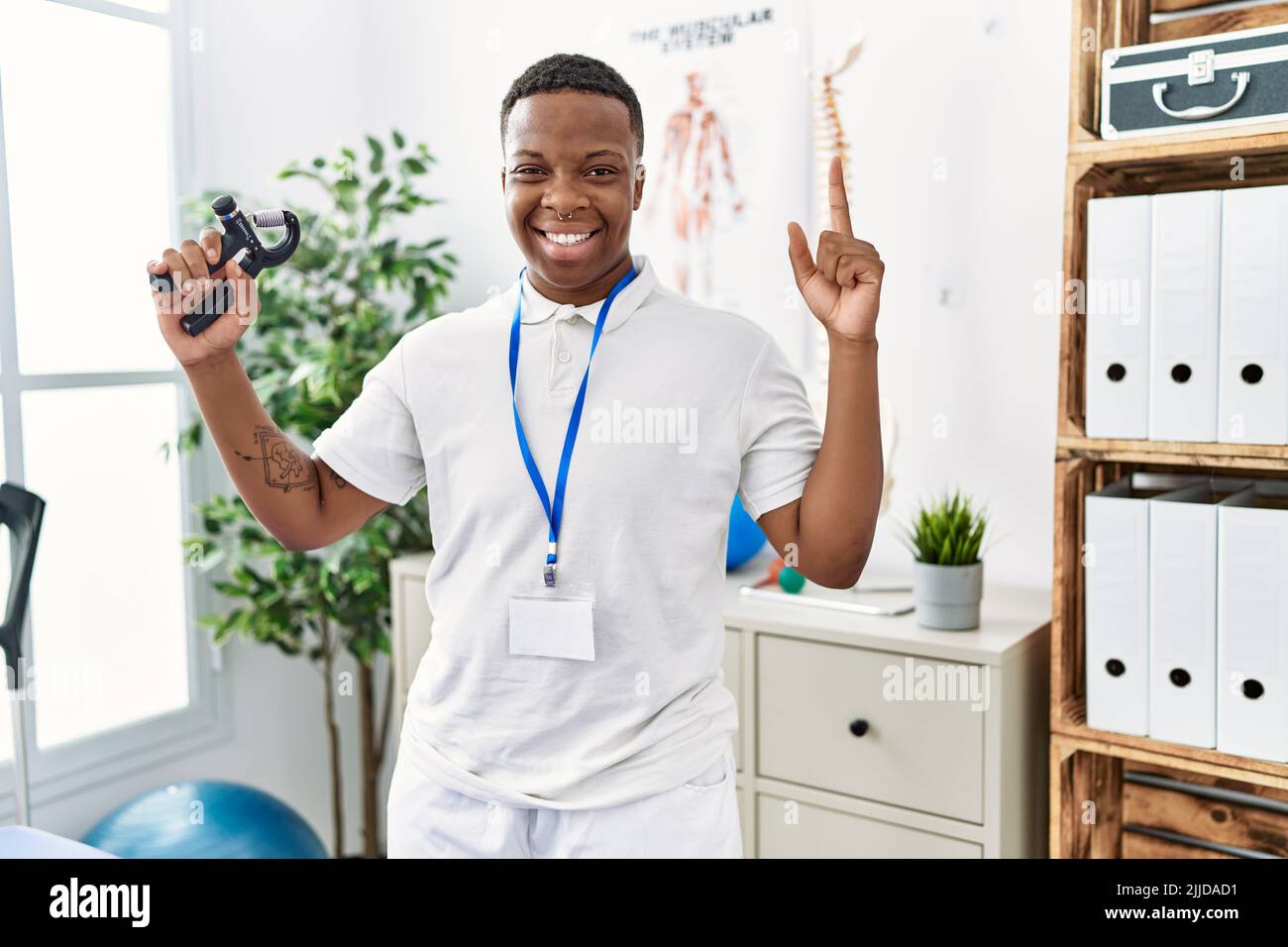 Young african physiotherapy man holding hand grip to train muscle ...