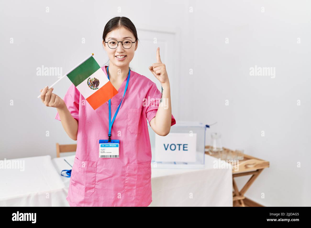 Young asian nurse woman at political campaign election holding mexico ...