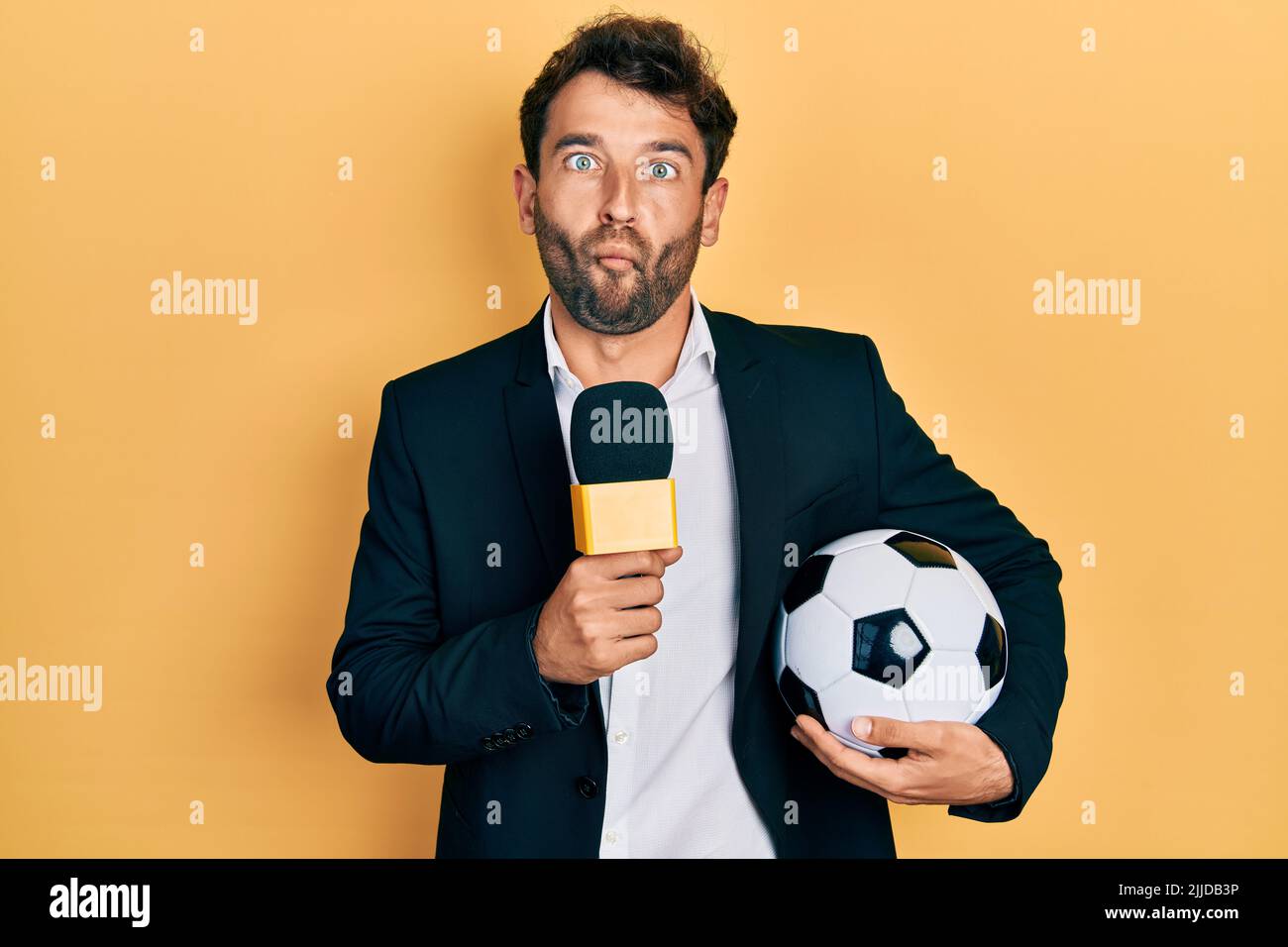 Handsome man with beard football reporter microphone making fish face ...