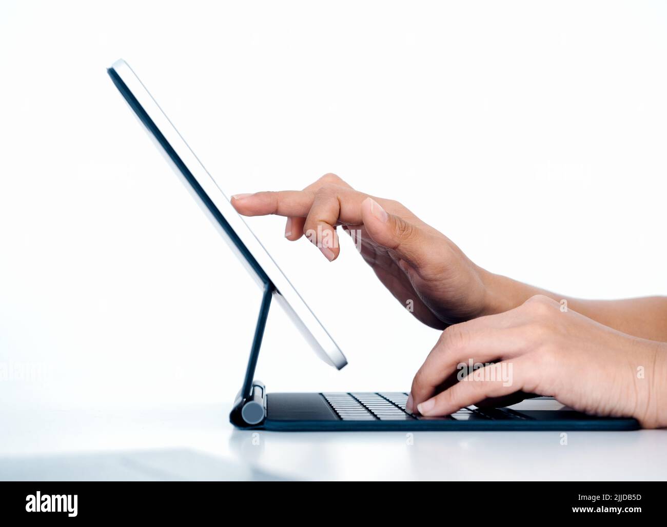 Person's finger touching, drawing on digital tablet screen while typing ...