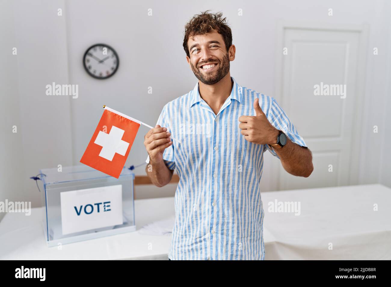 Young handsome man at political campaign election holding switzerland ...
