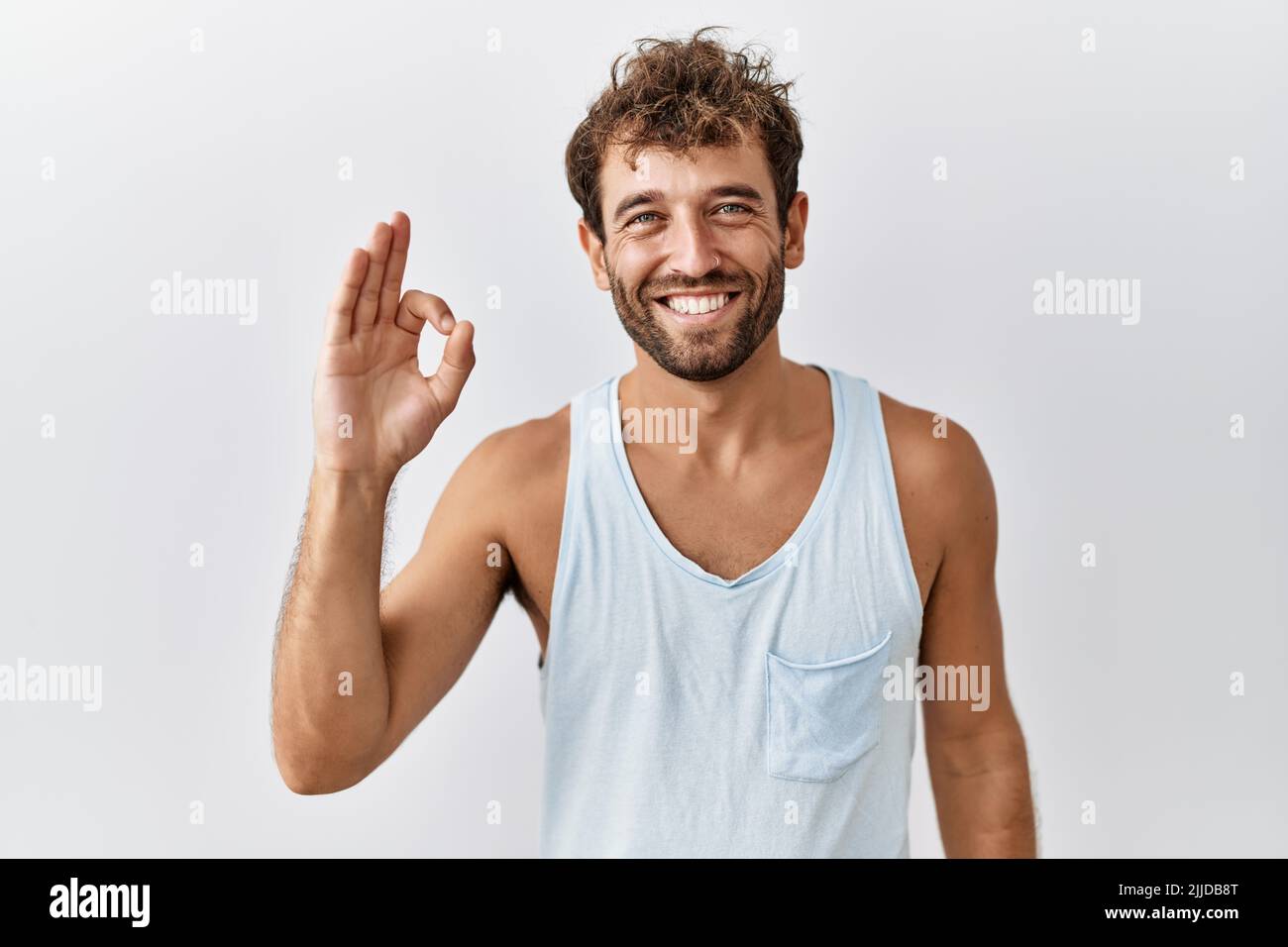 Young handsome man standing over isolated background smiling positive ...