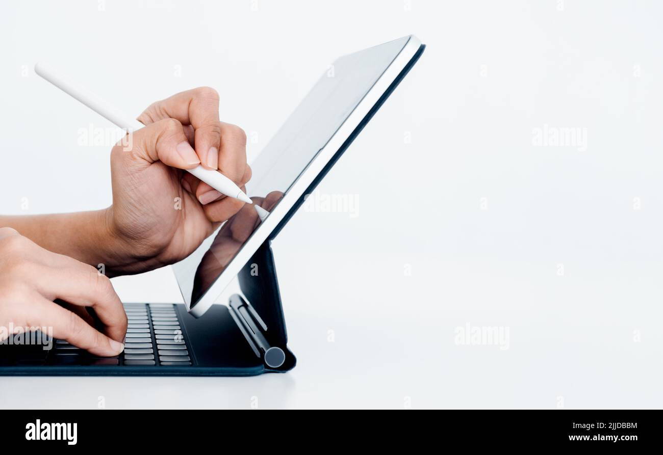 White electronic pen or pencil in person's hand, drawing on digital ...