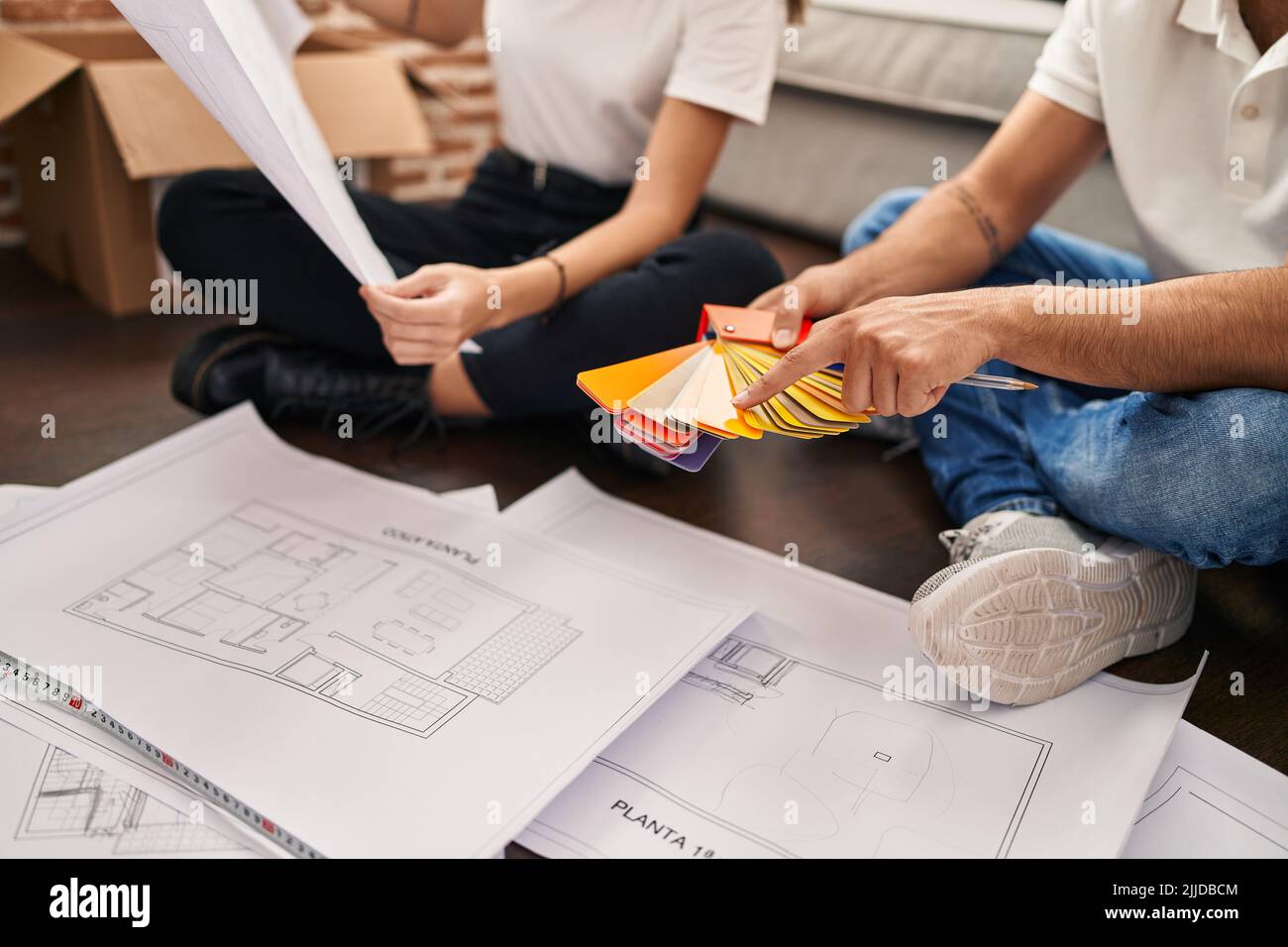 Man and woman couple choose paint color at new home Stock Photo - Alamy