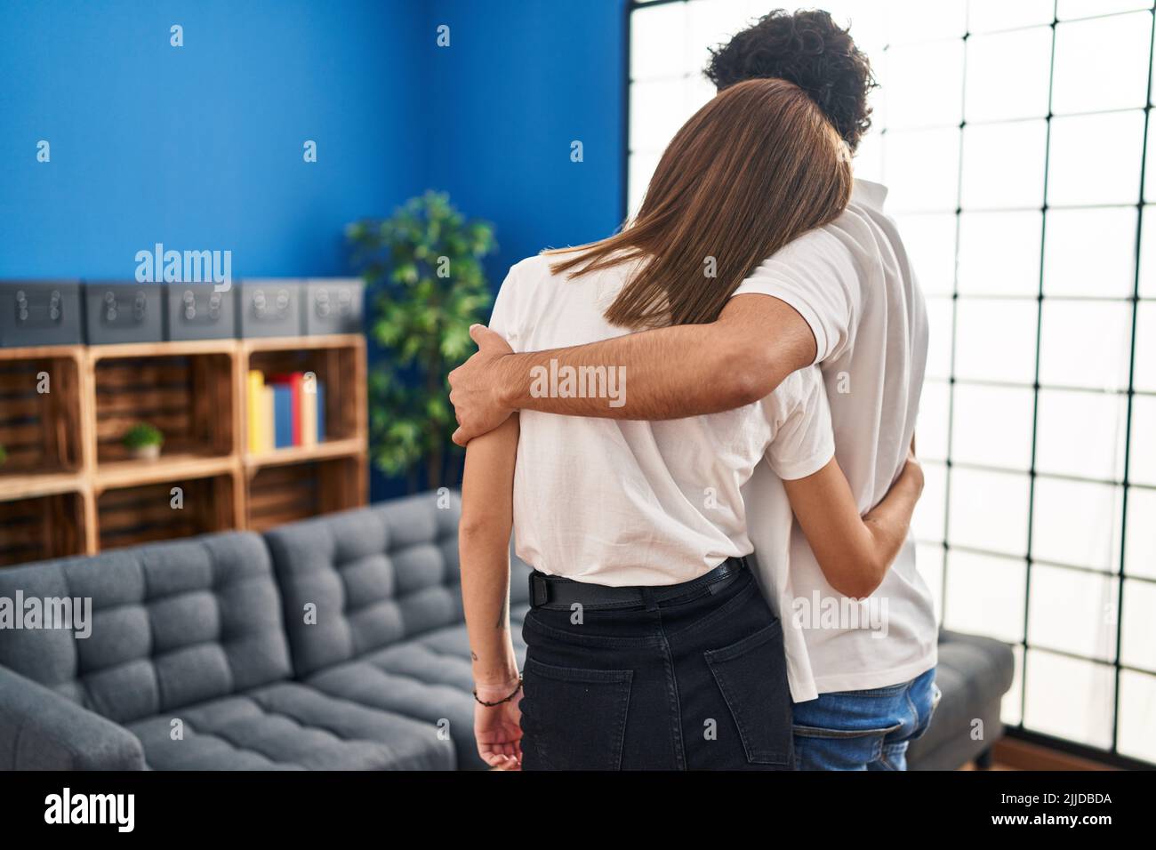 Man and woman on back view hugging each other at home Stock Photo - Alamy