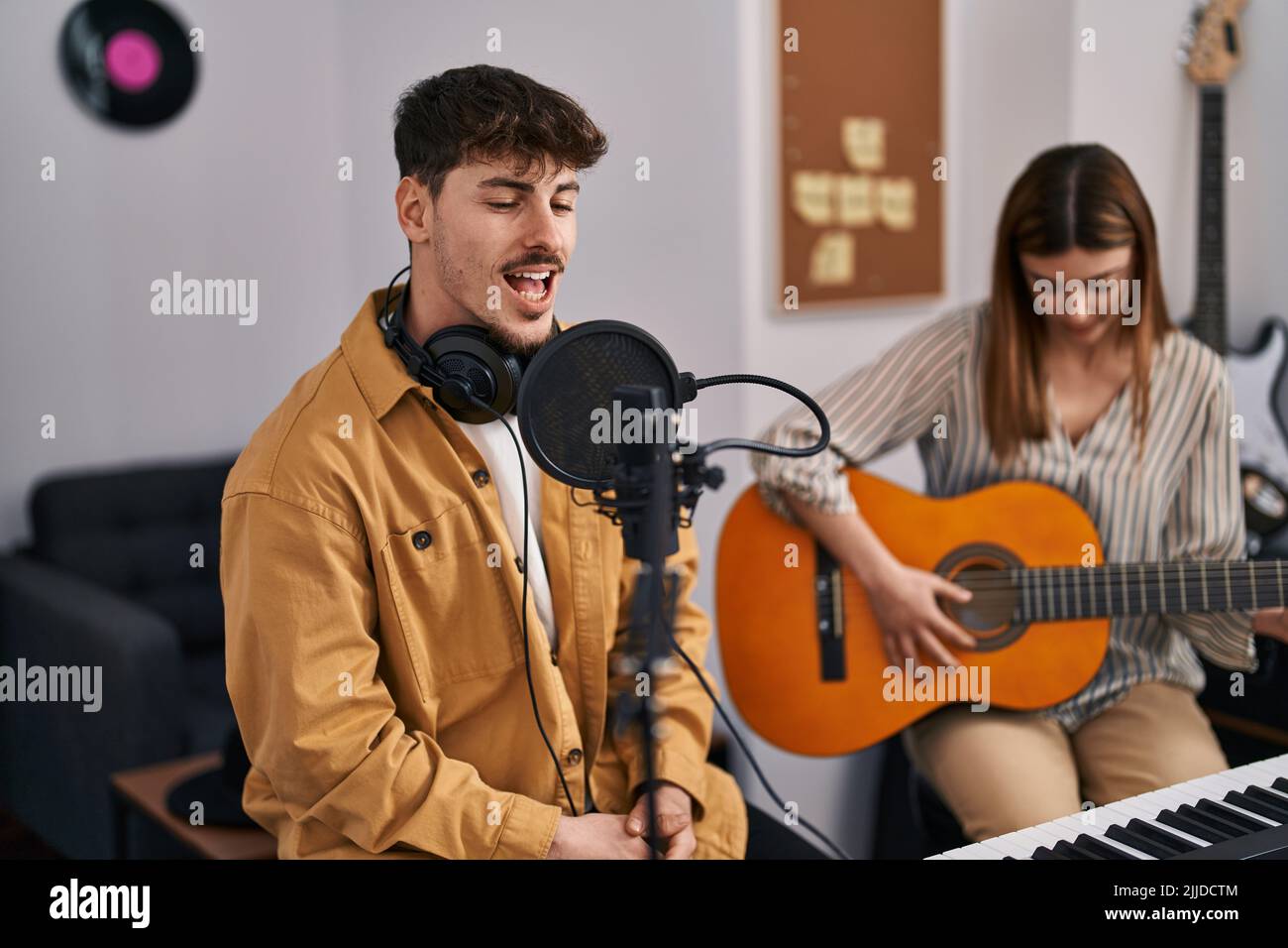 Mand and woman musicians singing song playing classical guitar at music ...