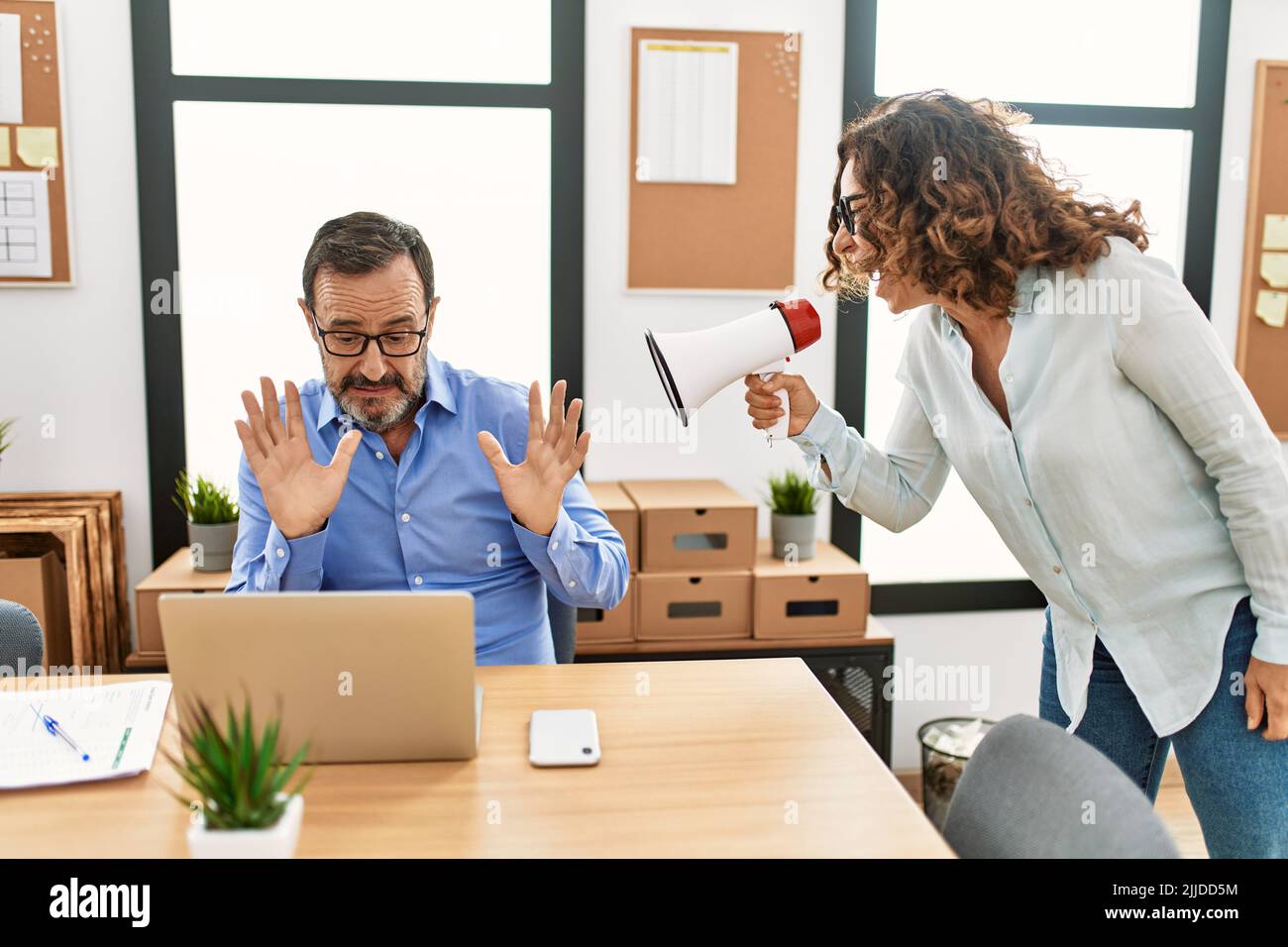 Middle age businesswoman angry with employee. Screaming using megaphone ...