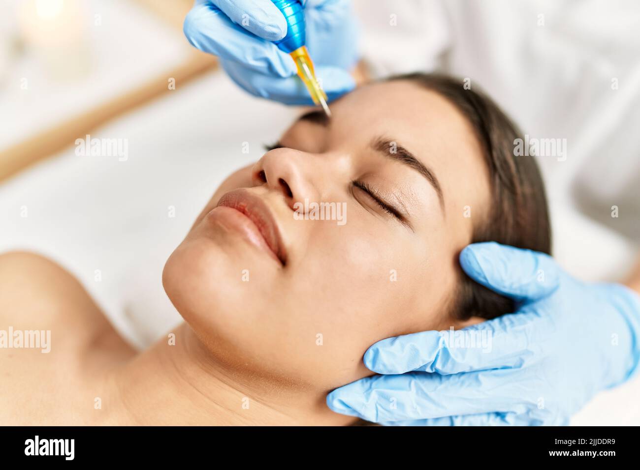 Young latin woman relaxed having microblading eyebrows treatment at ...
