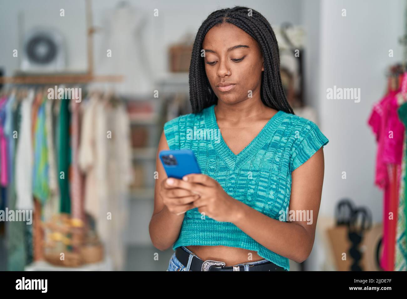 African american woman customer using smartphone at clothing store ...