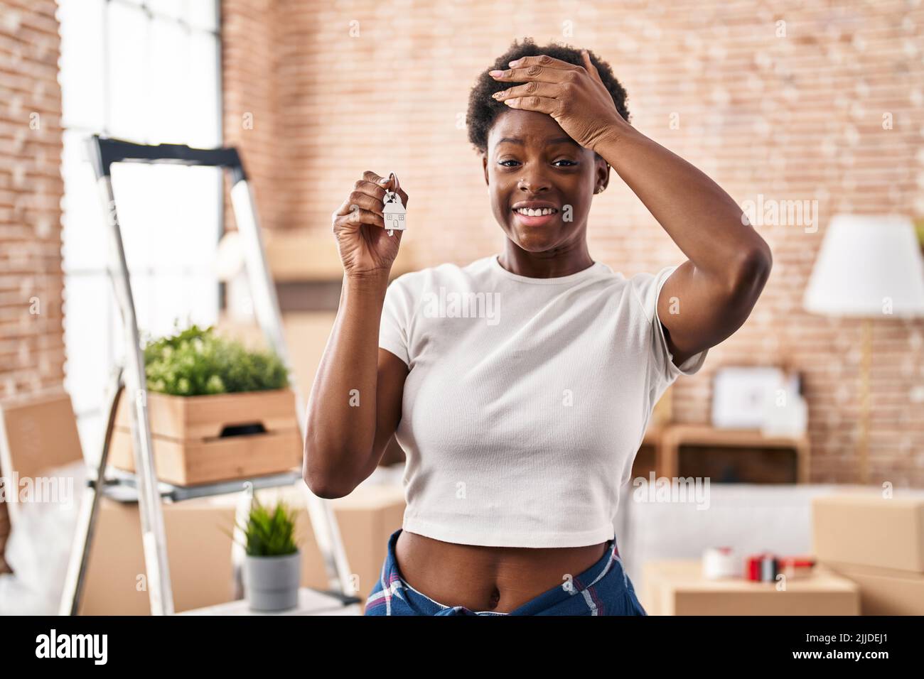 African american woman holding keys of new home stressed and frustrated ...