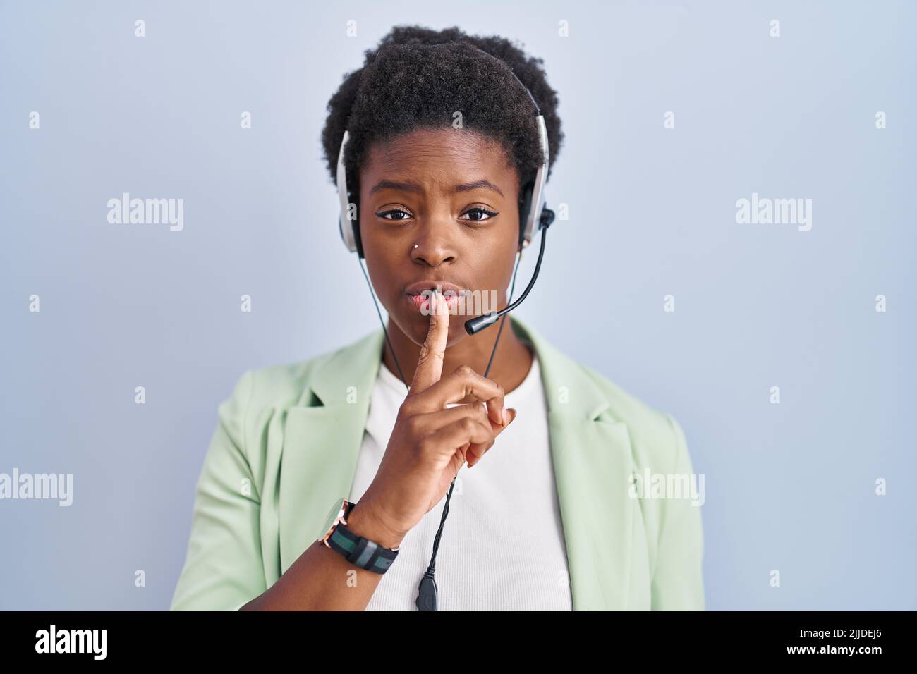 African american woman wearing call center agent headset asking to be ...
