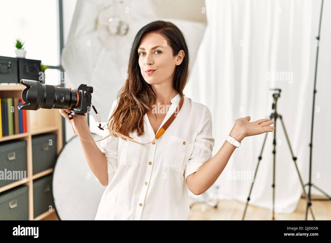 Beautiful caucasian woman working as photographer at photography studio ...
