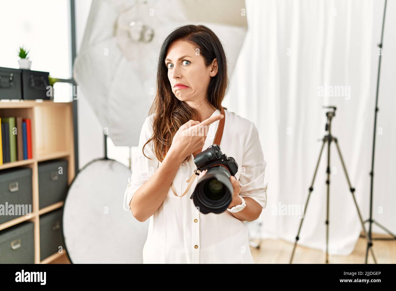 Beautiful caucasian woman working as photographer at photography studio ...