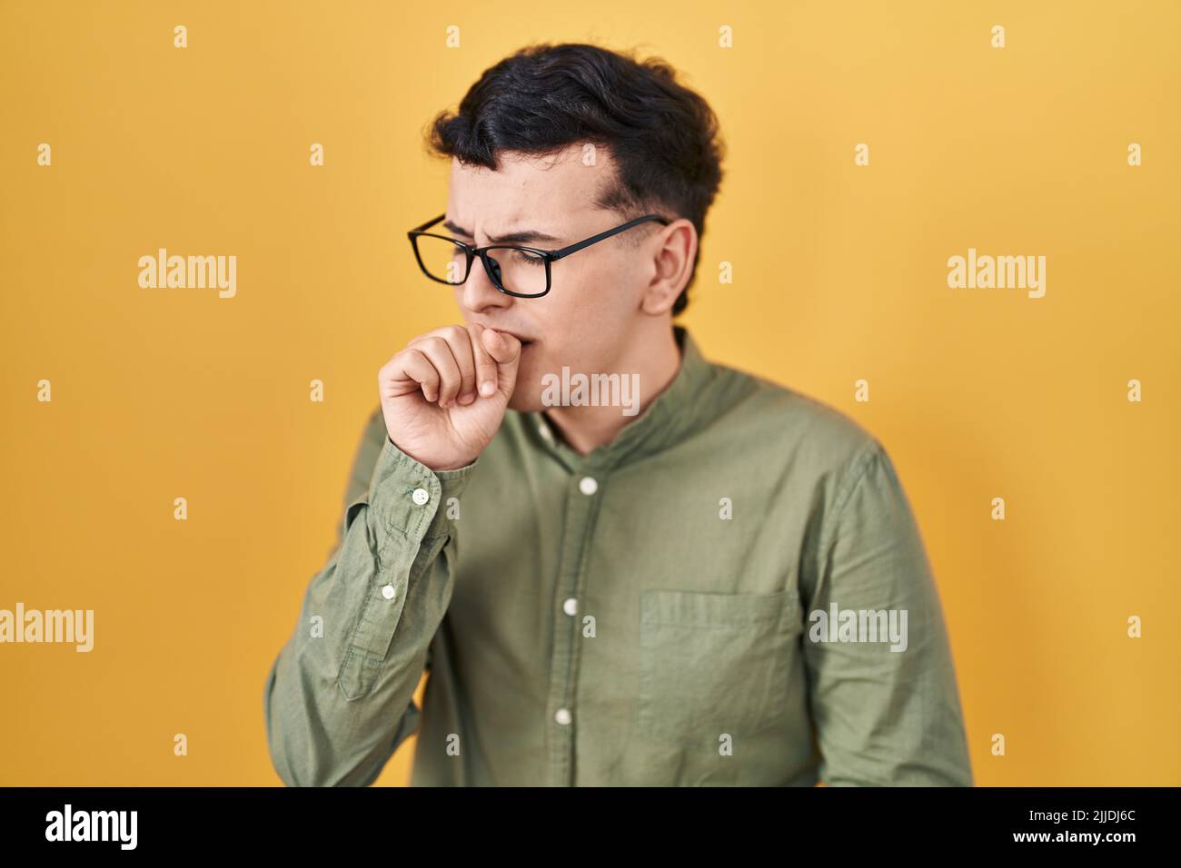 Non binary person standing over yellow background feeling unwell and ...