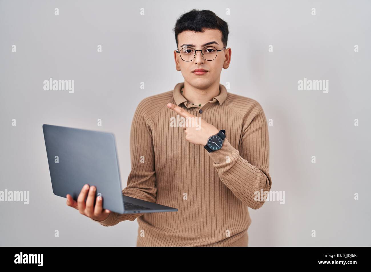 Non binary person using computer laptop pointing with hand finger to ...